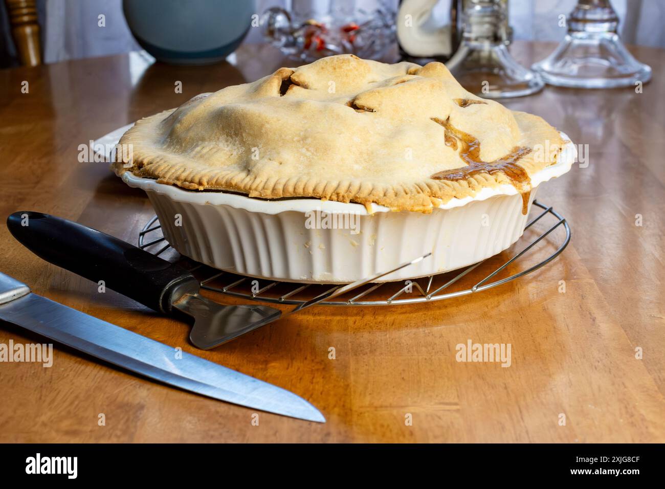 Making of an apple pie: Cutting the pie. Knife and pie server sit next ...