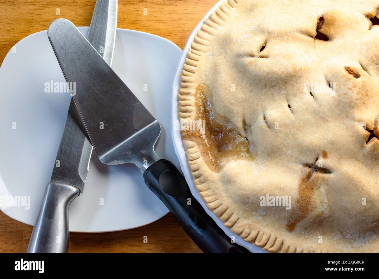 Making of an apple pie: Cutting the pie. Knife and pie server sit next ...
