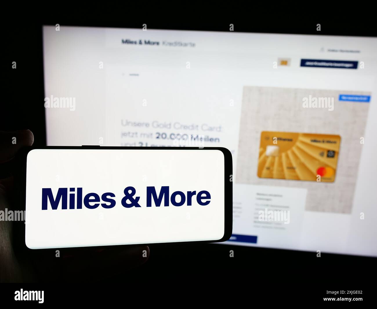 Person holding mobile phone with logo of frequent-flyer program Miles ...