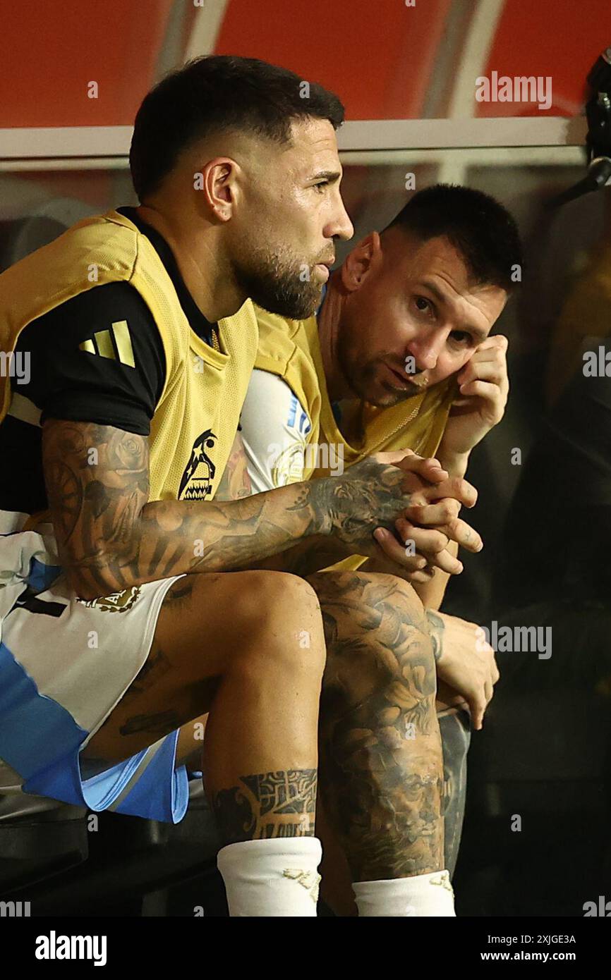 Argentine forward Lionel Messi (R) reacts while sitting on the bench ...