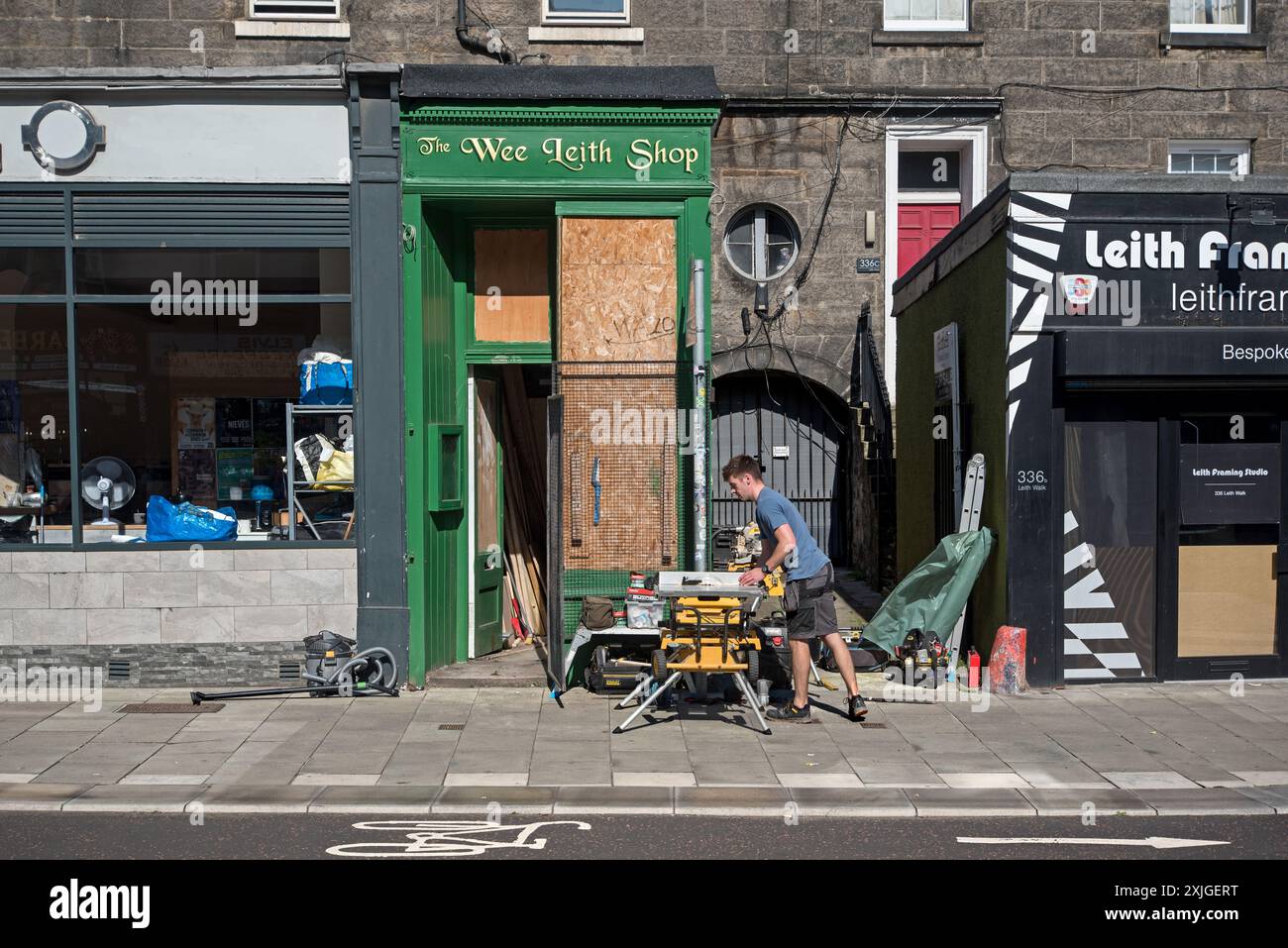 Workman renovating The Wee Leith Shop on Leith Walk, Edinburgh, UK Stock Photo - Alamy