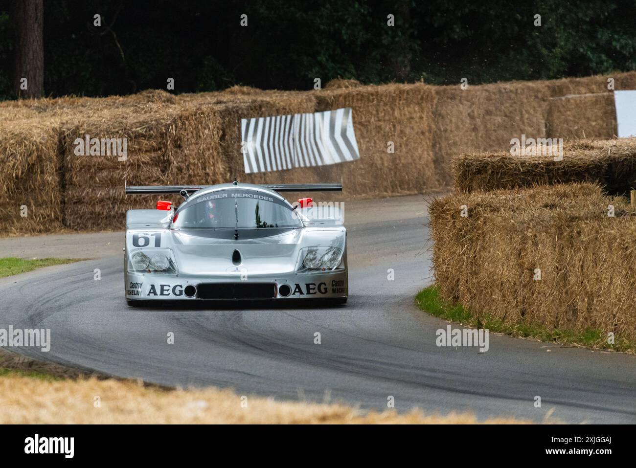 1989 Sauber-Mercedes C9 race car driving up the hill climb track at the Goodwood Festival of ...