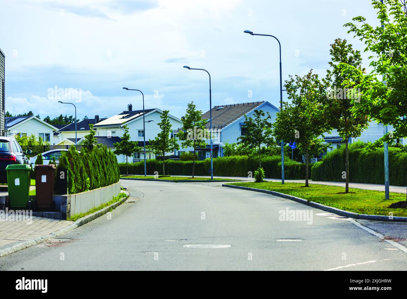 Residential street in Swedish suburb with modern houses, trees, and ...