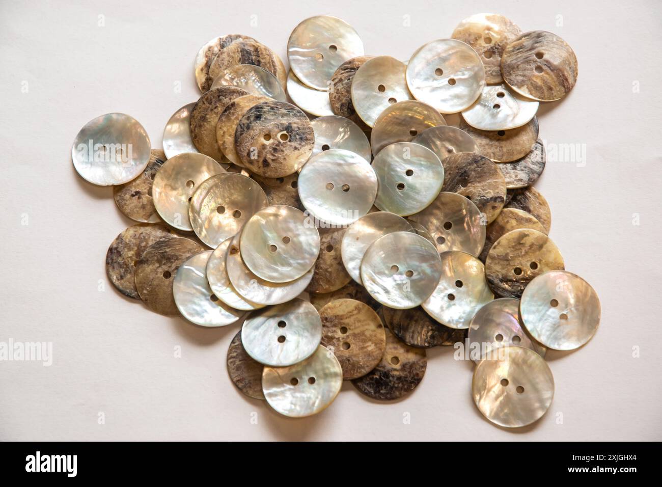 Pile of nacre (mother of pearl) sewing buttons closeup on white ...