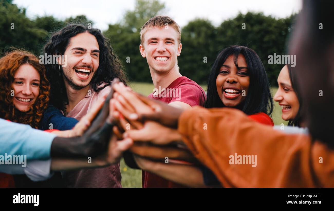 Team stacking hands in circle. Group of friends celebrating together at ...