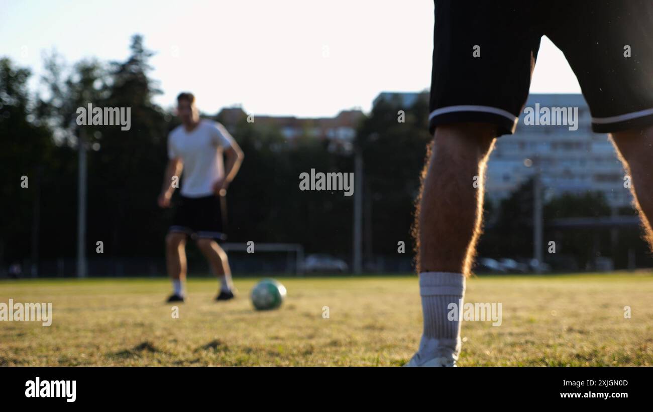 Male feet of professional footballers passing soccer ball on stadium at ...