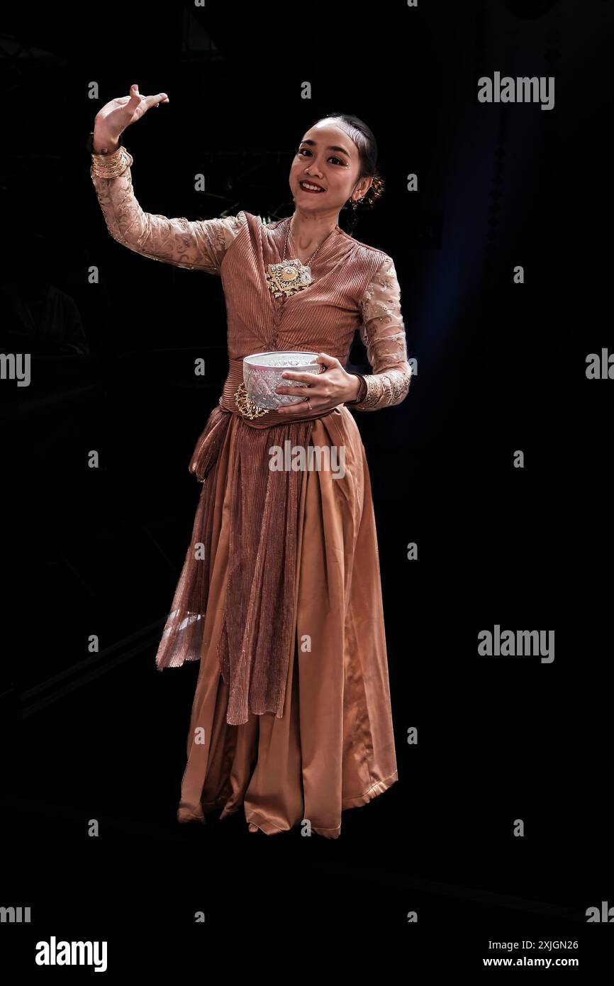 Thai classical dancer in long gown holds traditional Songran water bowl ...