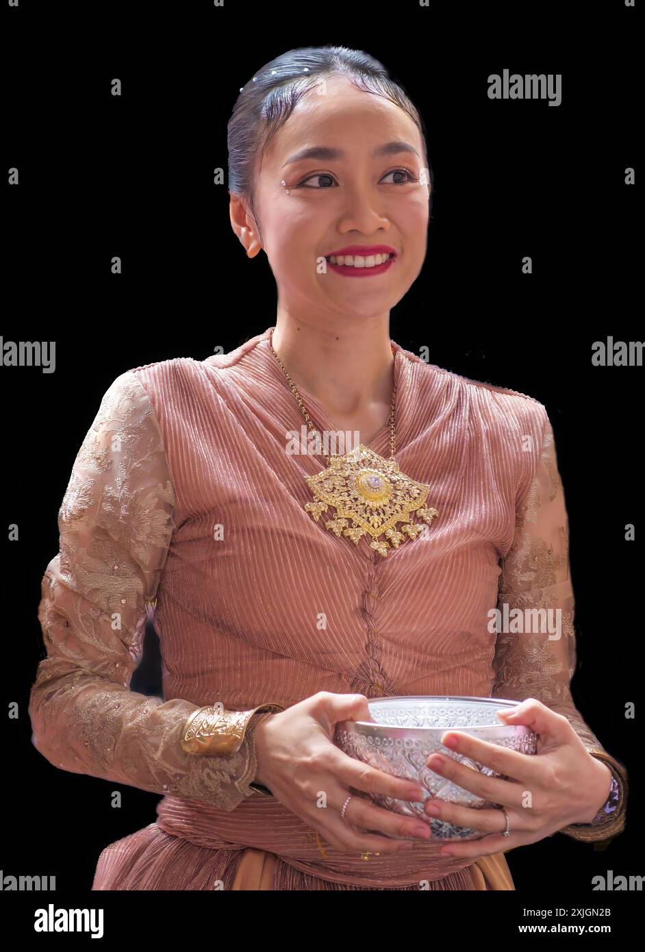 Thai classical dancer in traditional dress smiles & holds Songran water ...