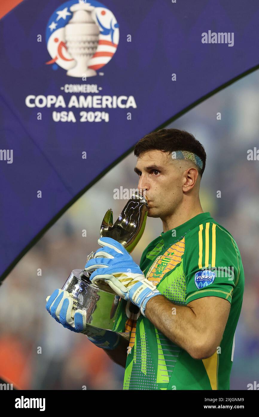 Argentina's goalkeeper Emiliano Martinez holds and kisses the trophy as ...