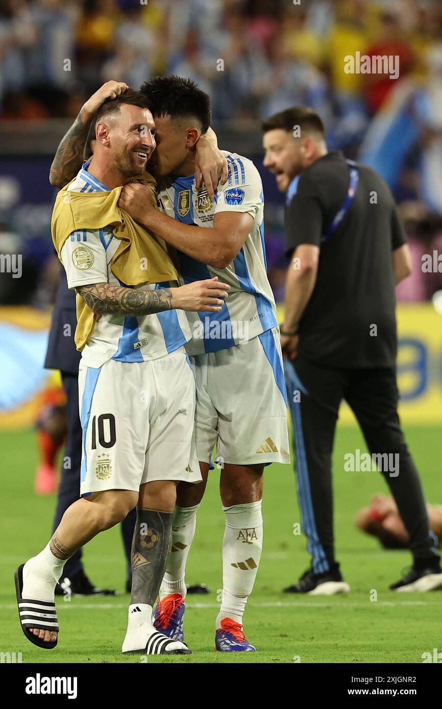 Argentina's defender Lisandro Martinez (C) hughs forward Lionel Messi ...