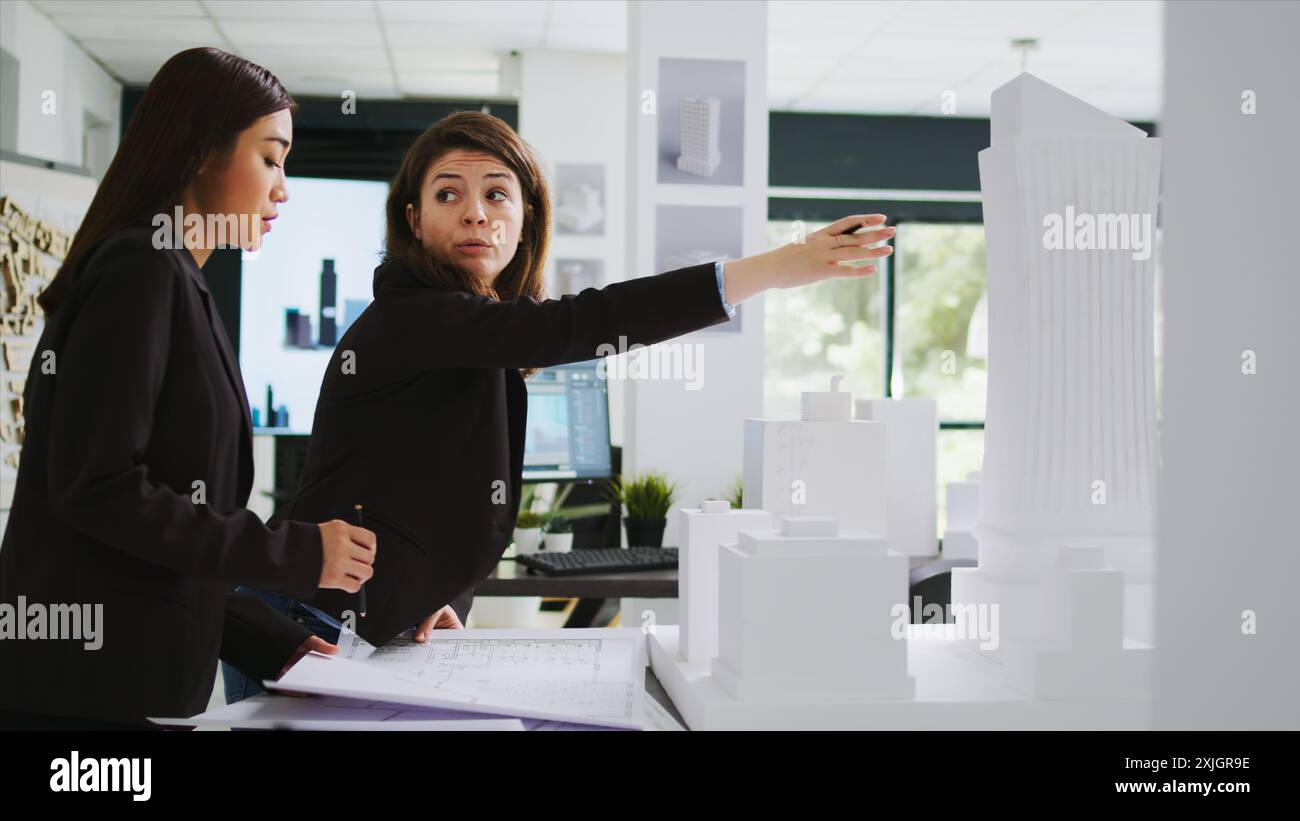 Cad experts examining architectural blueprints at agency, holding 3d ...