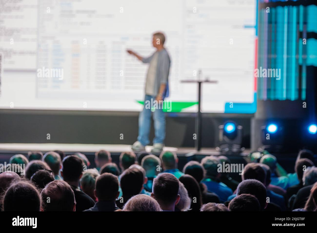 Speaker giving a presentation to a large audience at a technology ...