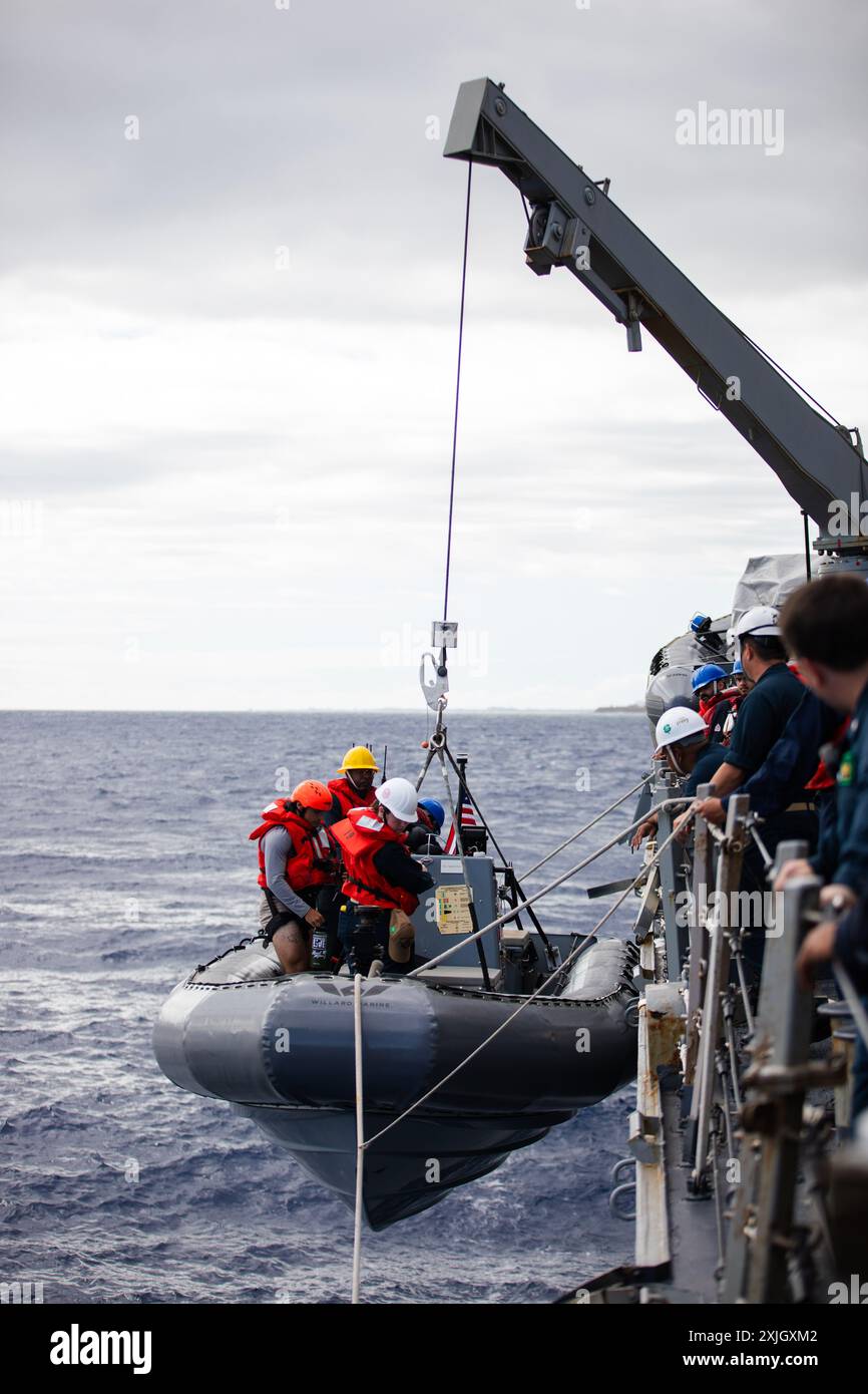 A rigid-hull inflatable boat is lowered from the Arleigh Burke-class ...