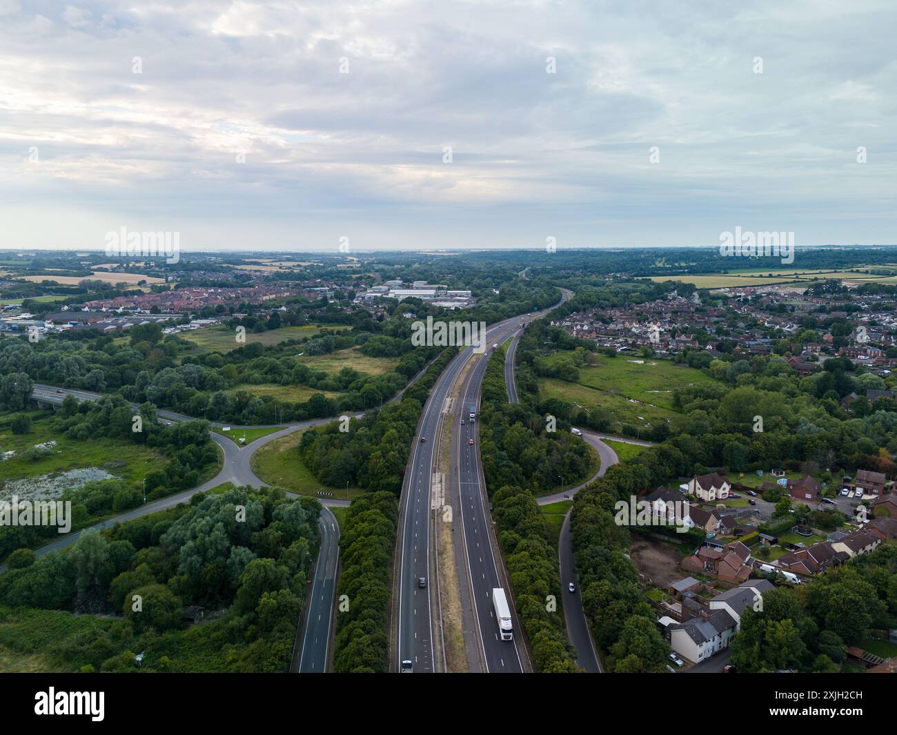 Aerial view of a highway cutting through a green countryside with a ...