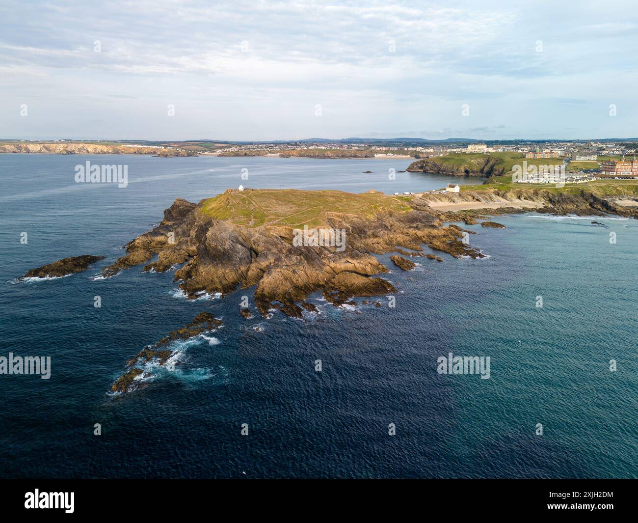 Aerial view of a rocky headland with a small white house, creating a ...