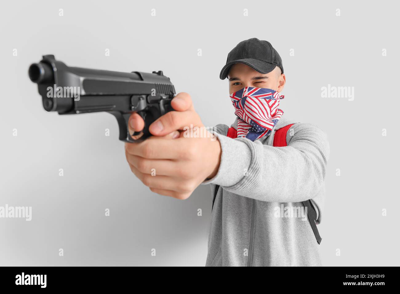 Male student with gun on light background. School shooting concept ...