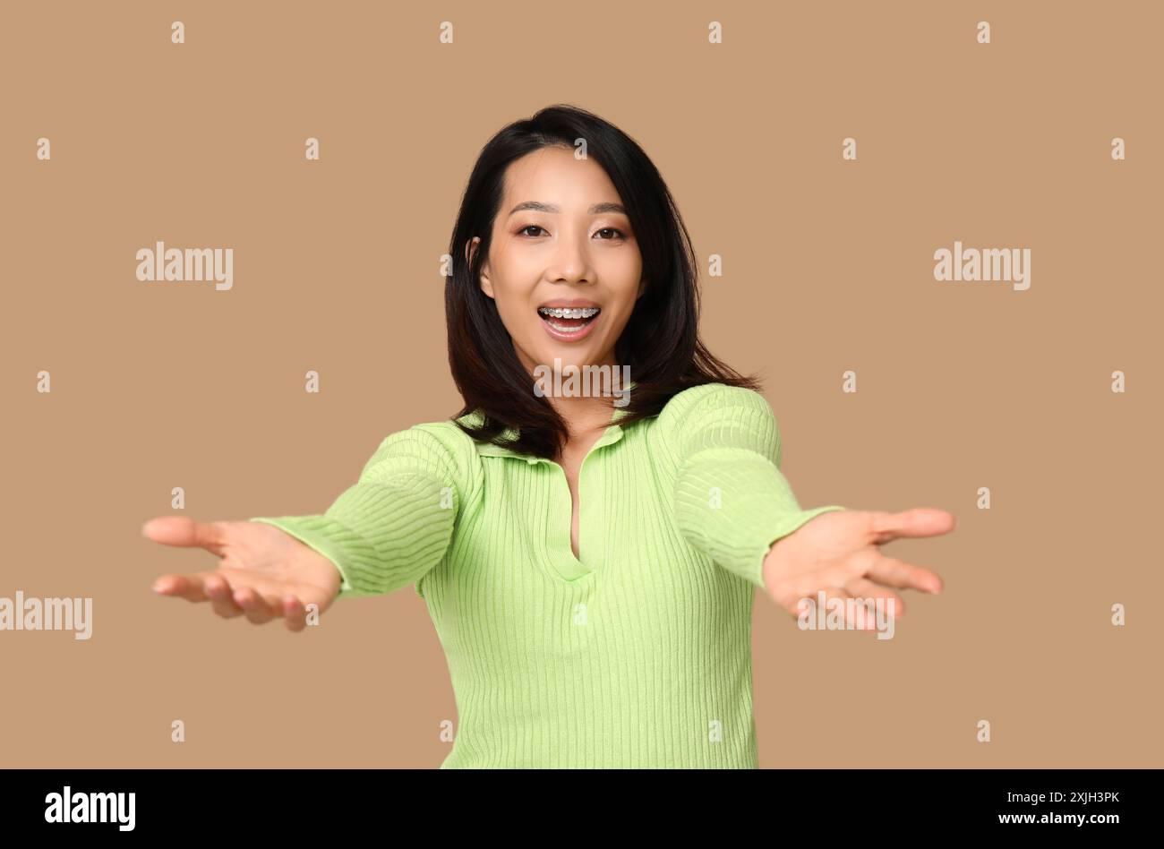 Young Asian woman opening arms for hug on brown background Stock Photo ...