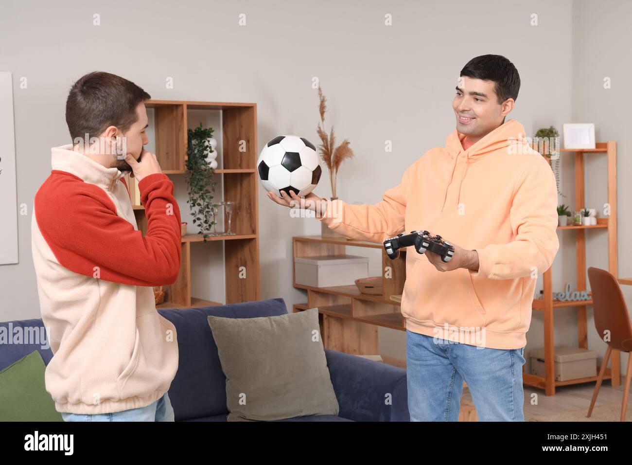Handsome young brothers with soccer ball spending time together in ...