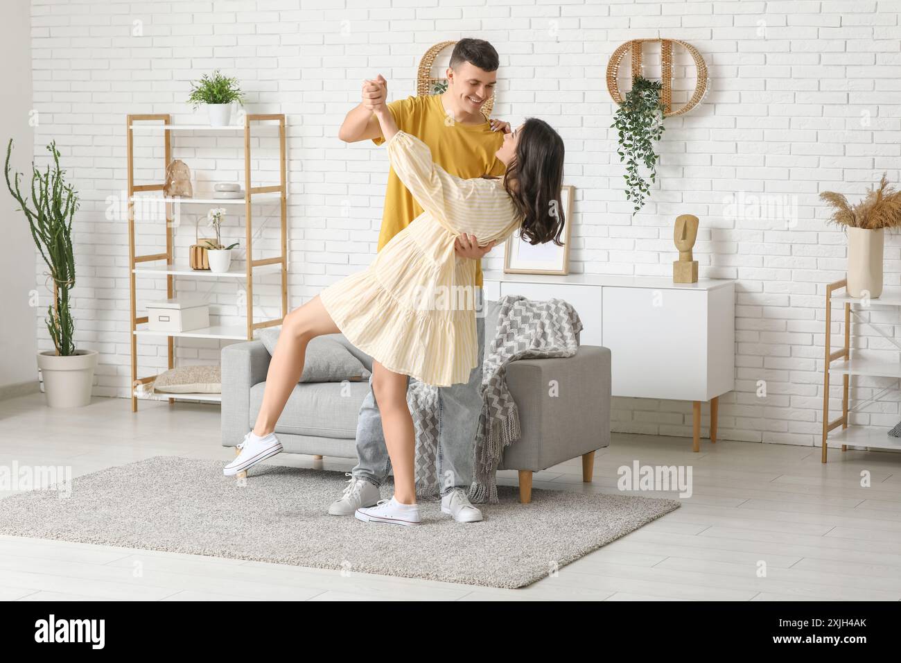 Beautiful young couple dancing at home Stock Photo - Alamy