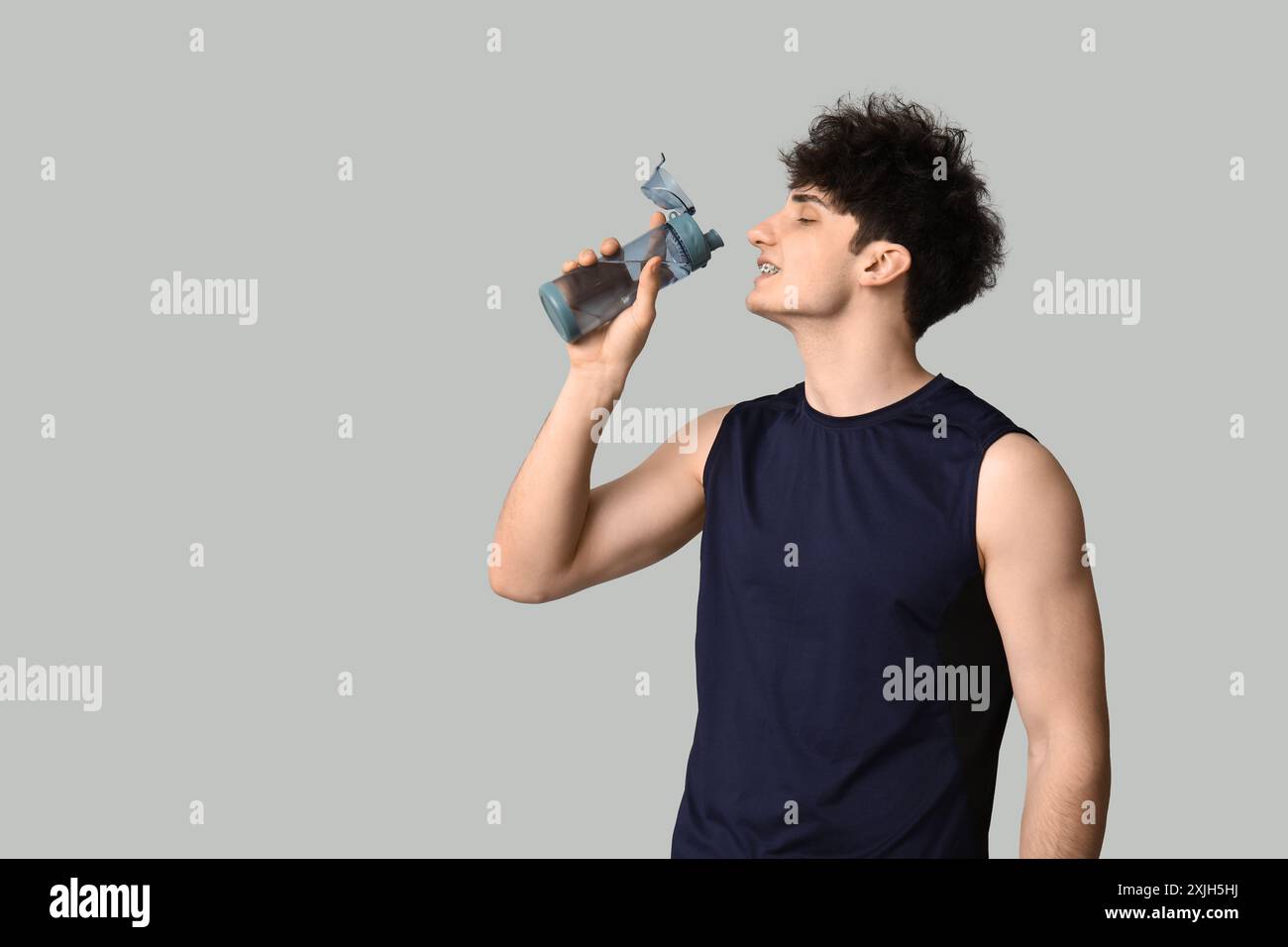 Sporty guy drinking water on white background Stock Photo - Alamy