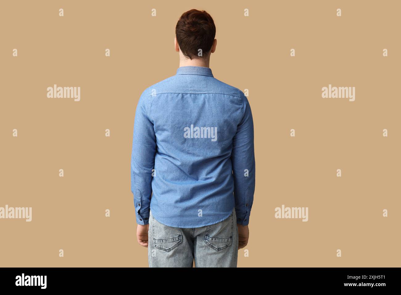 Young man in stylish blue collar shirt on brown background, back view ...