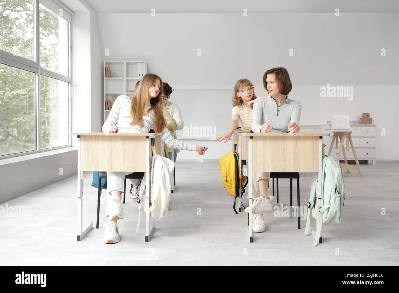 Students handing cheat sheet over during exam in classroom Stock Photo ...