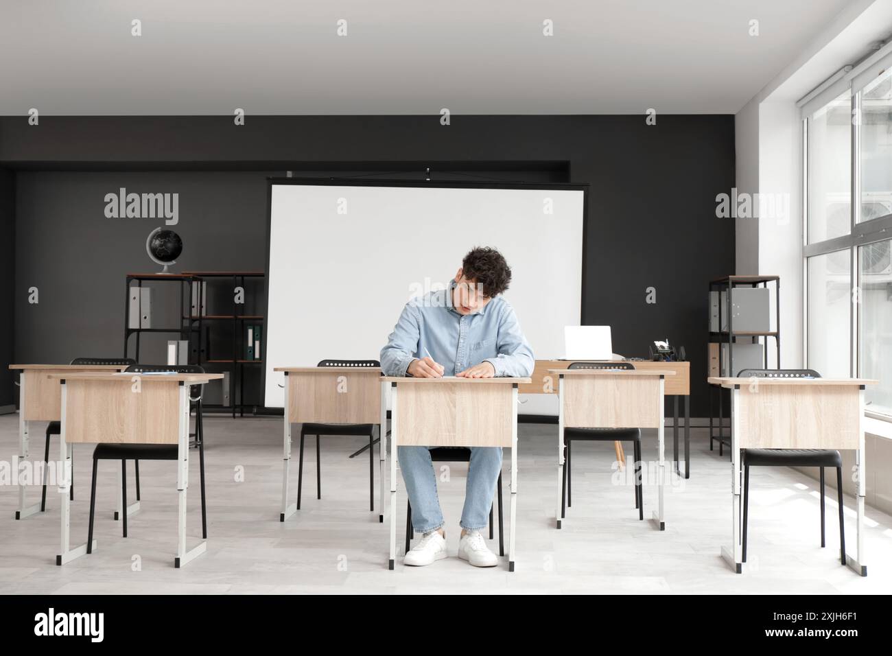 Male student passing exam in classroom Stock Photo - Alamy