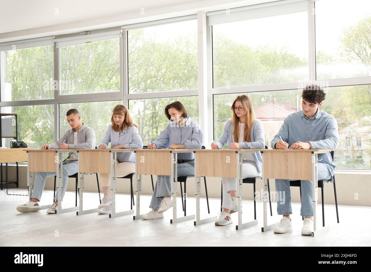 Group of students passing exam in classroom Stock Photo - Alamy