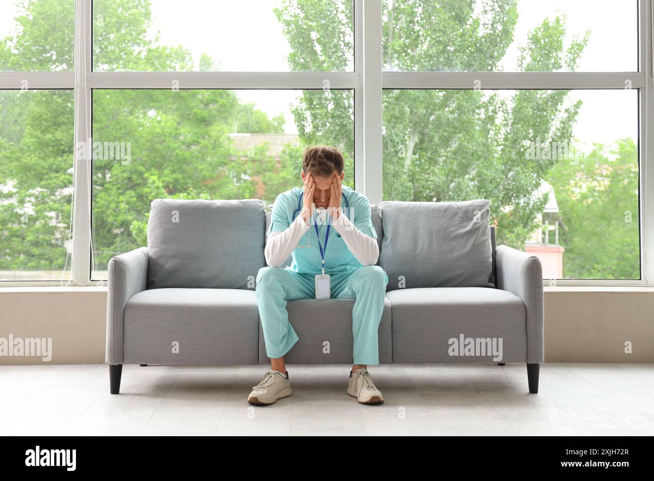 Stressed medical intern sitting on sofa in clinic Stock Photo - Alamy
