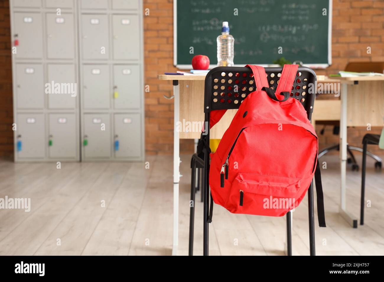 Red backpack on chair in classroom, closeup Stock Photo - Alamy