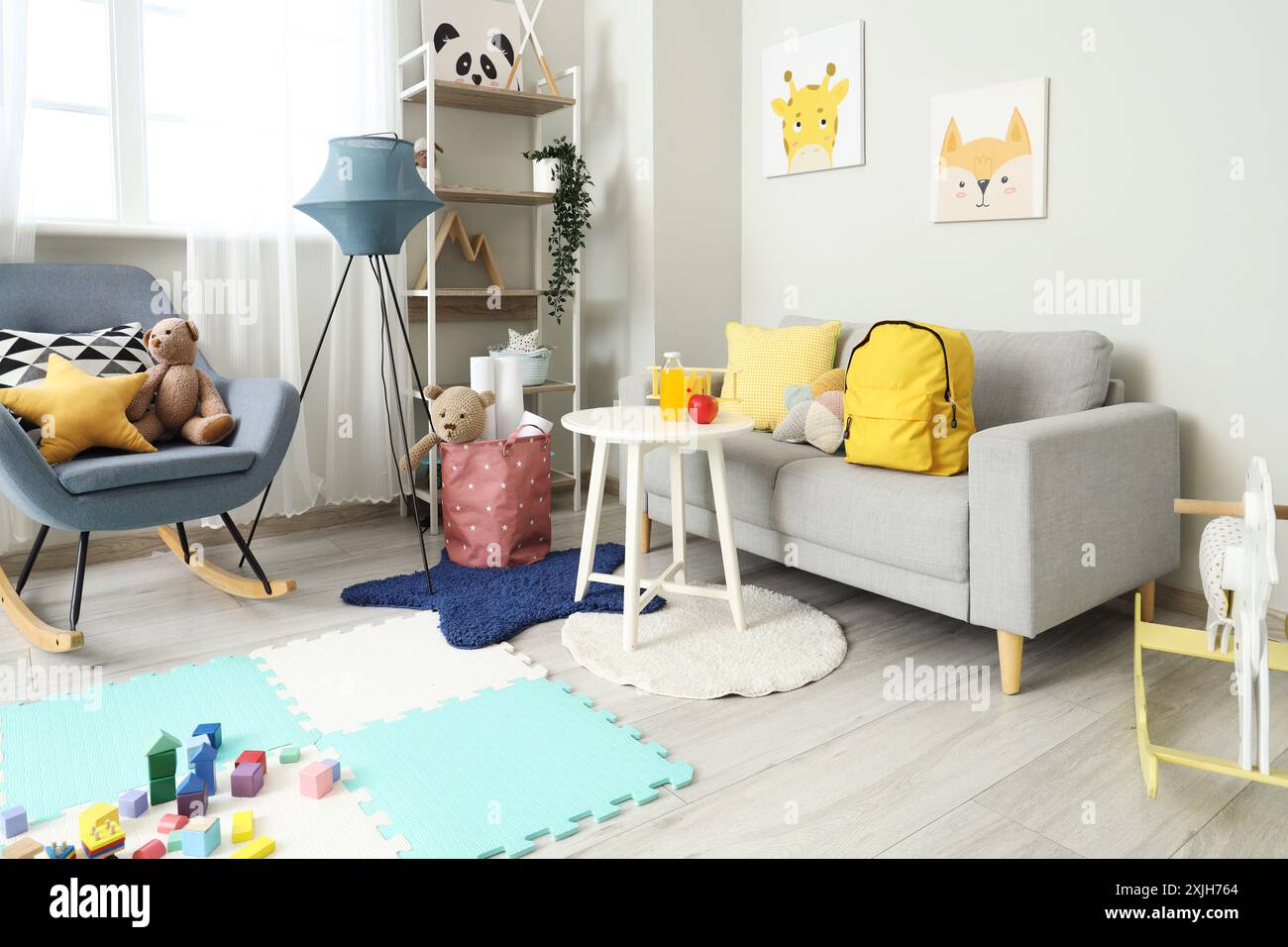 Interior of children's room with backpack on sofa and table Stock Photo ...