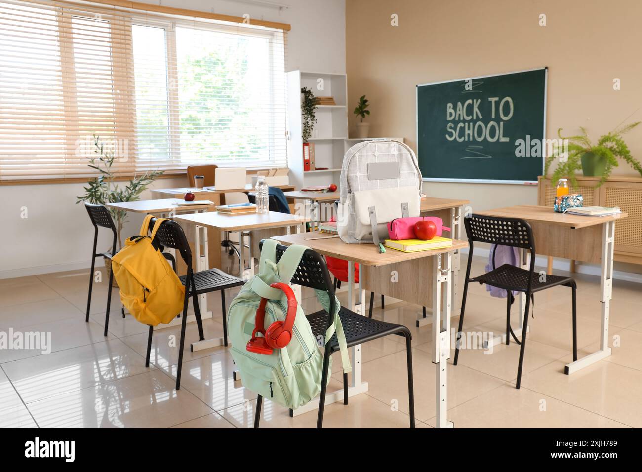 Interior of empty classroom with chalkboard, desks and backpacks Stock ...