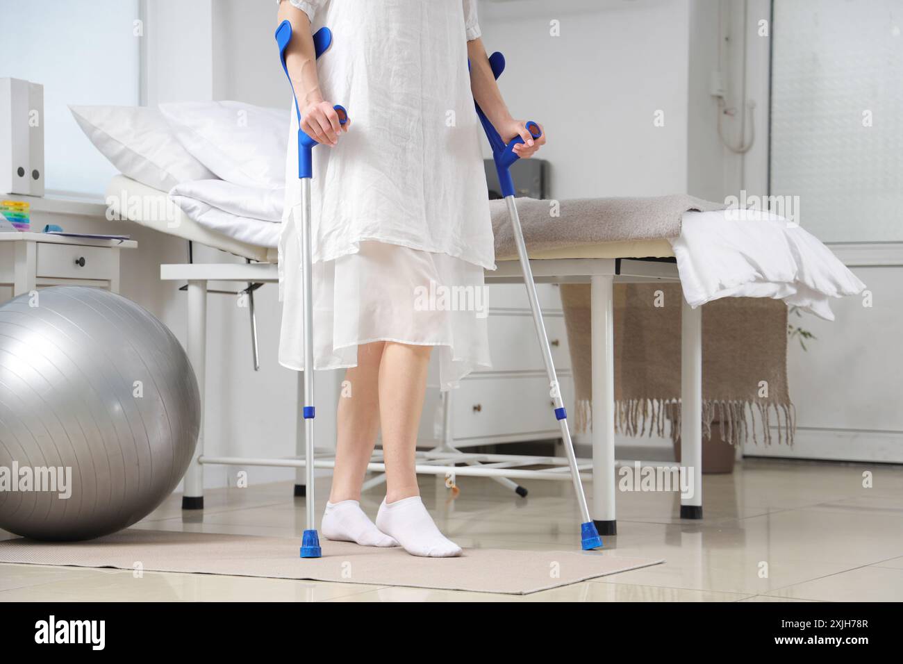 Female patient with crutches walking in hospital ward Stock Photo - Alamy