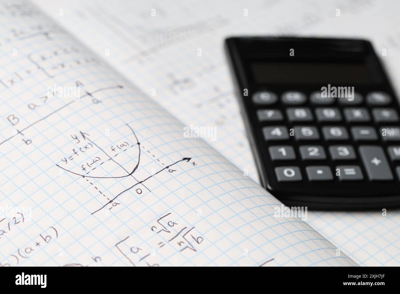 Copybook with handwritten maths formulas and calculator as background ...