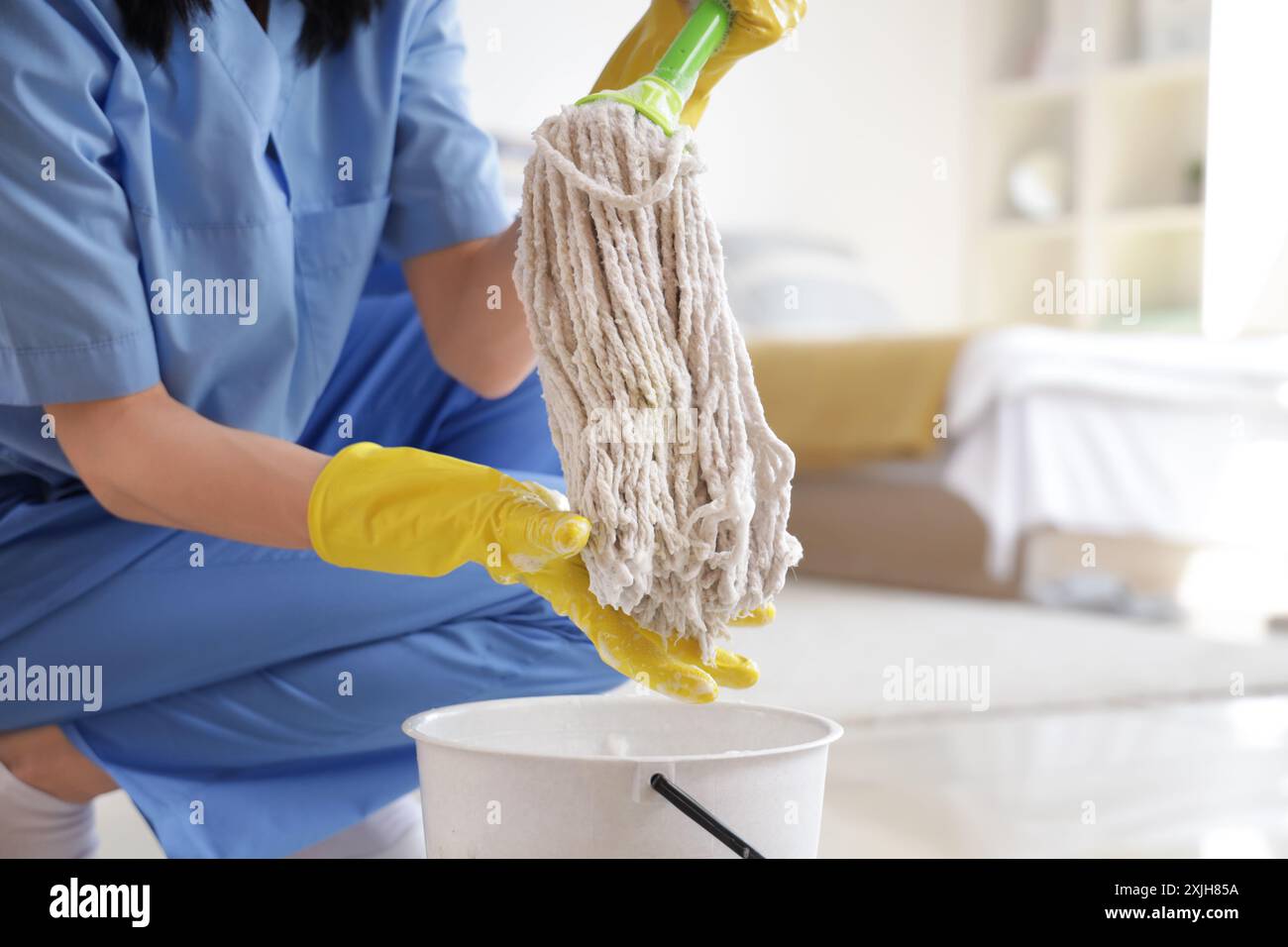 Female janitor wringing mop head in dorm room, closeup Stock Photo - Alamy