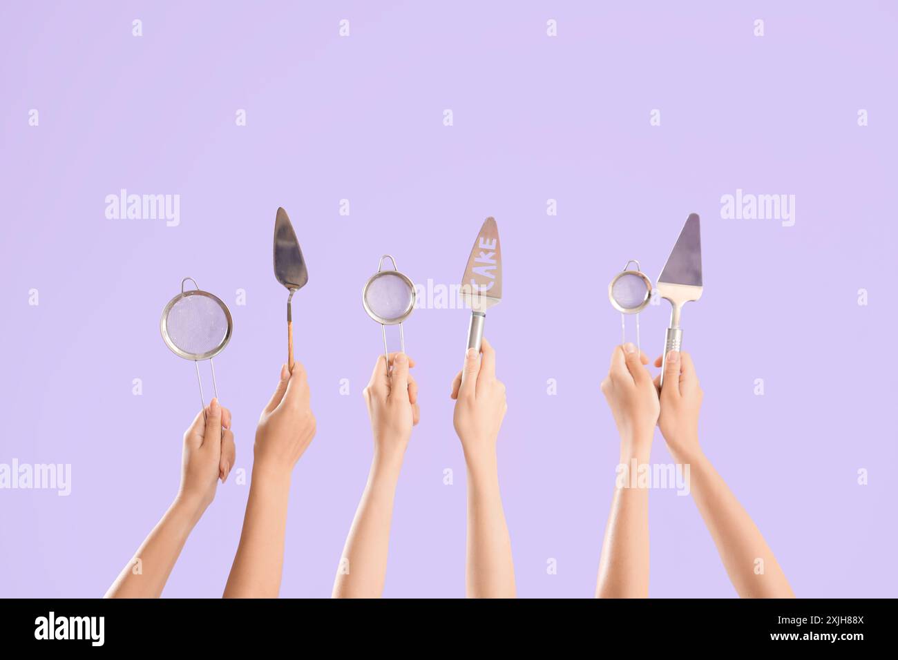 Female hands with spatulas and sieves on purple background Stock Photo ...