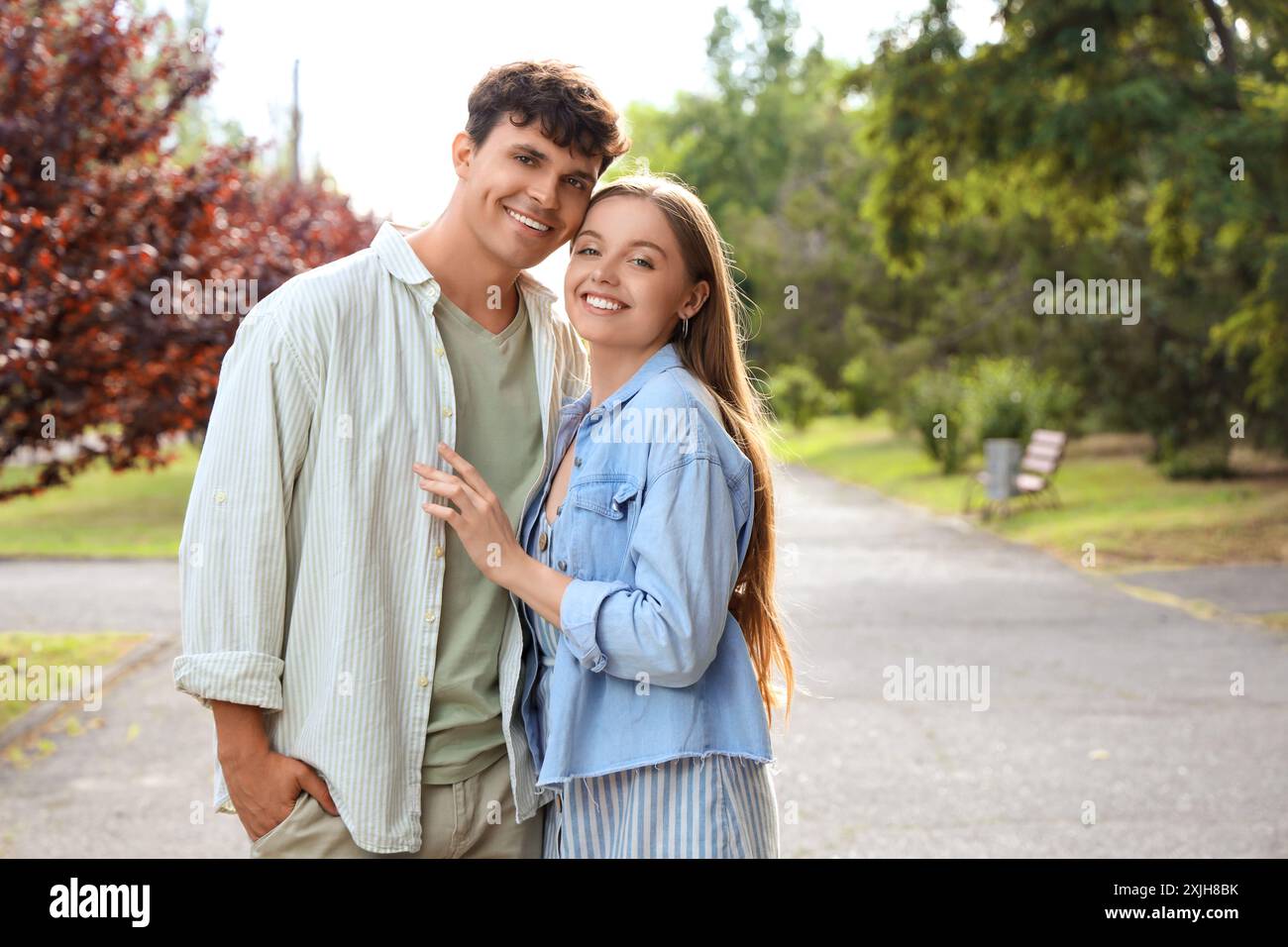 Beautiful young happy couple hugging in summer park Stock Photo - Alamy