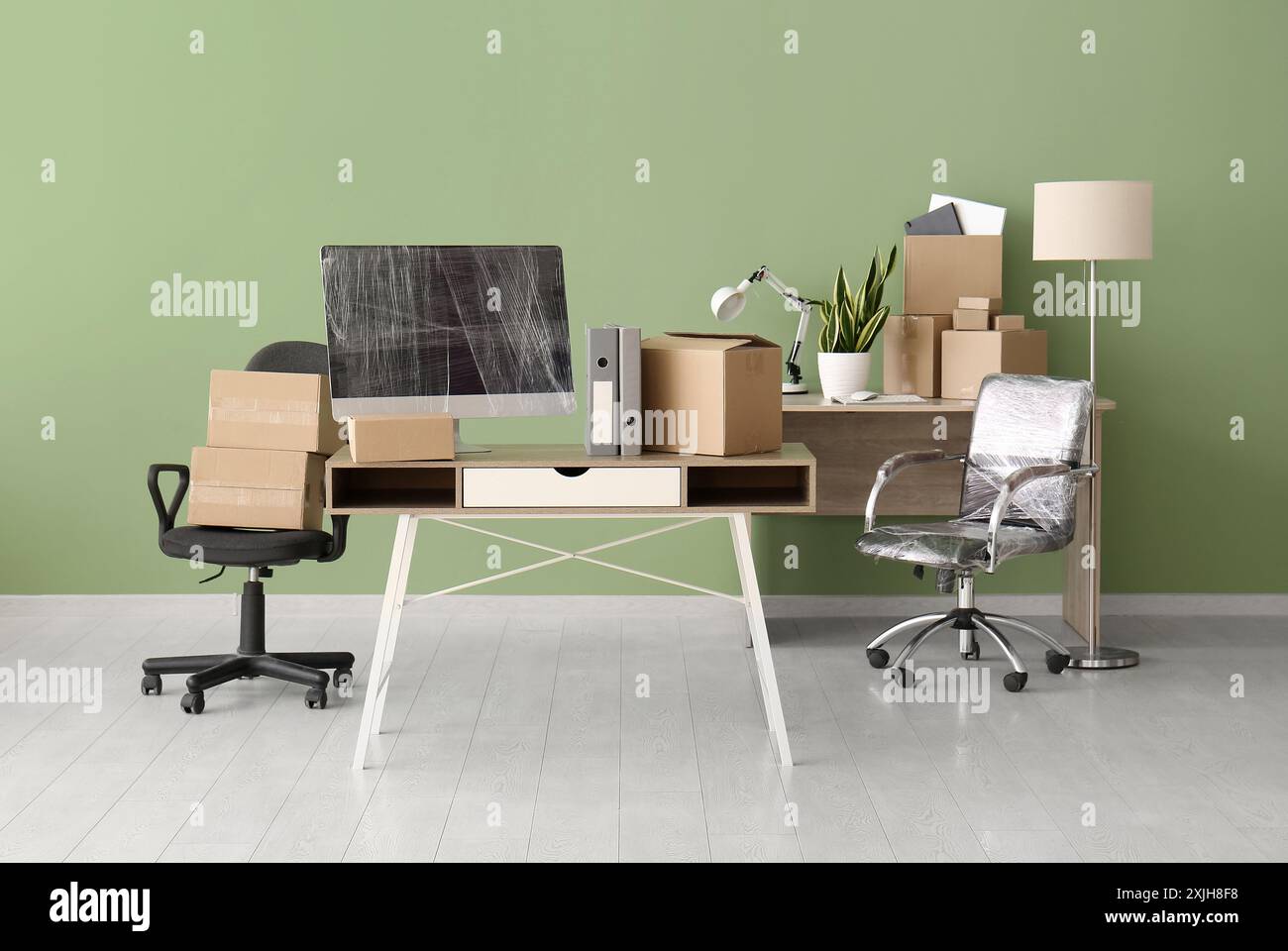Desks with cardboard boxes and chairs in office on moving day Stock ...