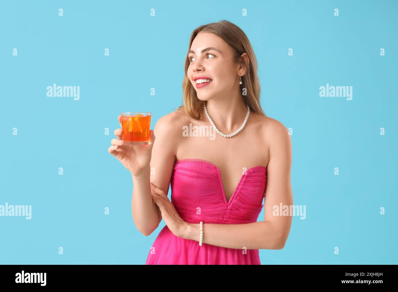 Beautiful young woman with aperol spritz cocktail on blue background ...