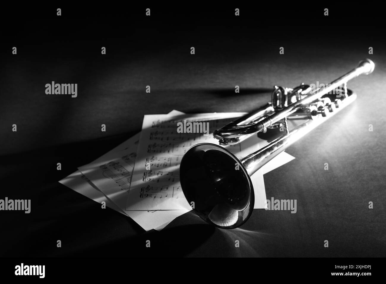 Shiny trumpet and music sheets on dark background. Wind musical ...