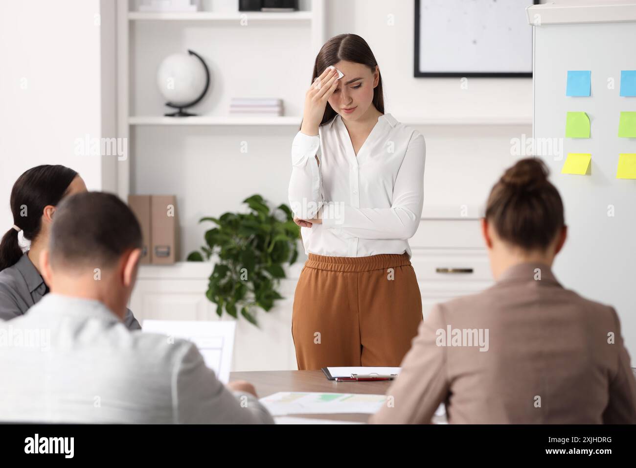 Woman feeling embarrassed during business meeting in office Stock Photo ...