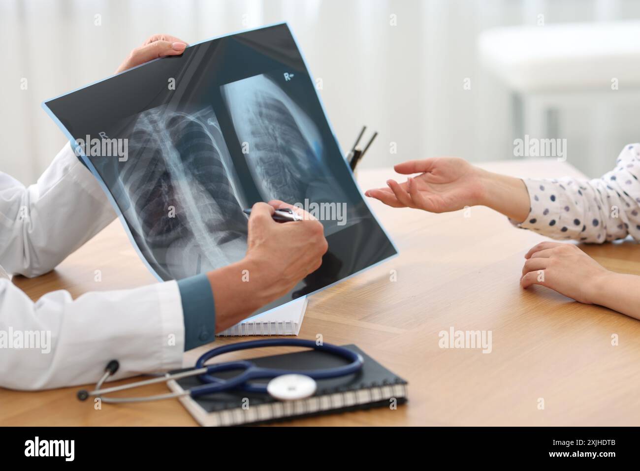 Lung disease. Doctor showing chest x-ray to her patient in clinic ...