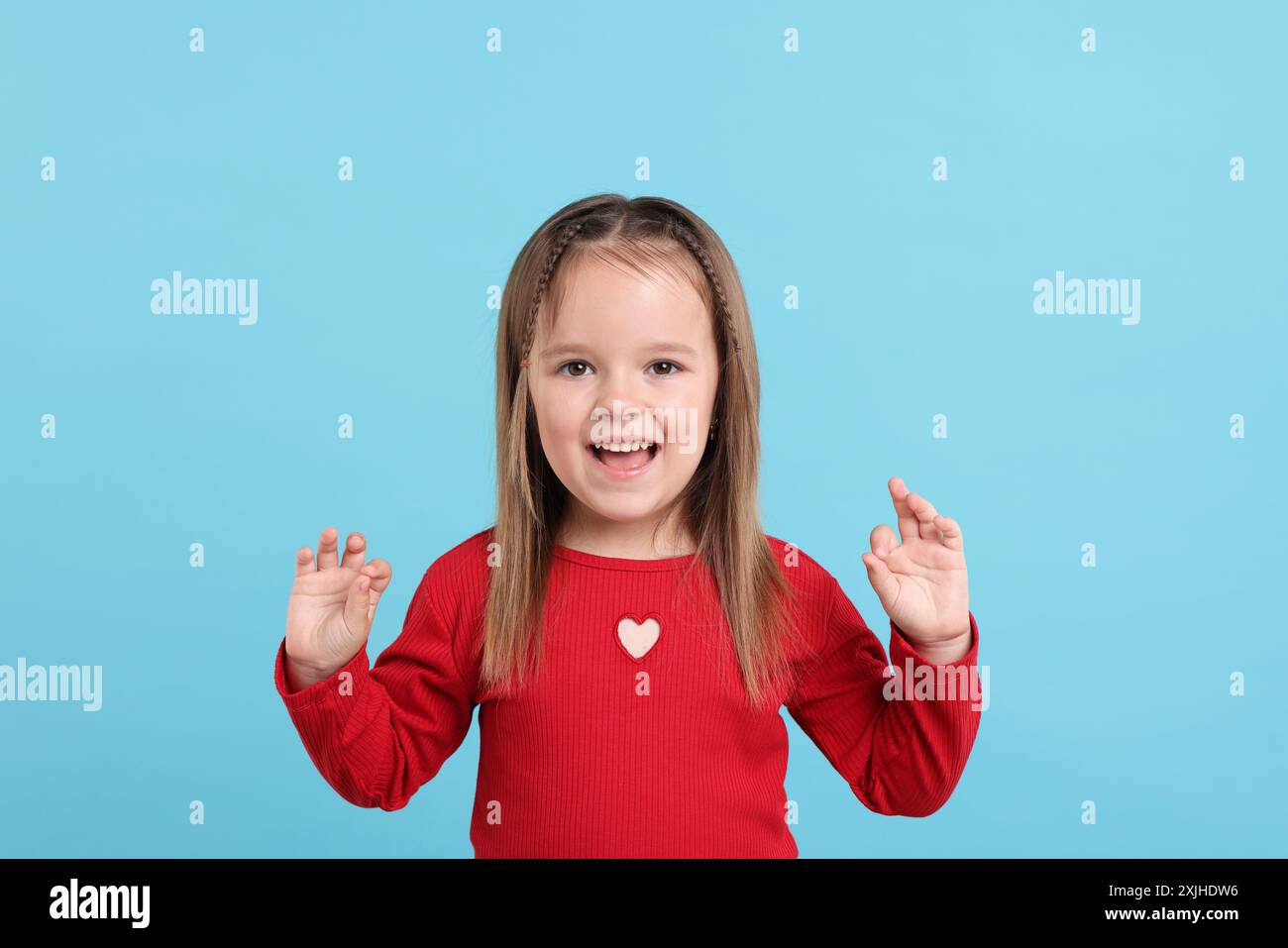 Portrait of happy little girl on light blue background Stock Photo - Alamy