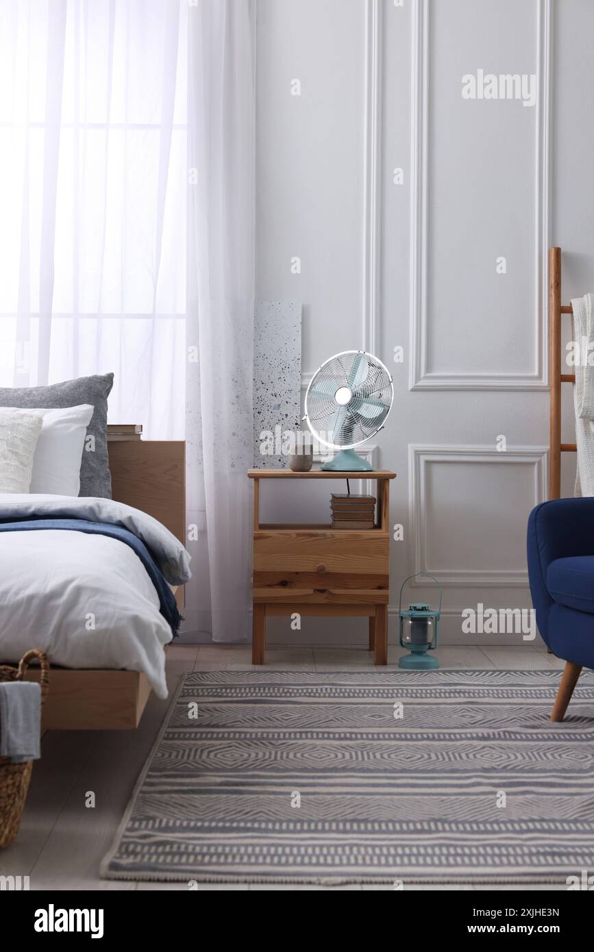 Stylish living room interior with bed, bedside table and fan Stock ...