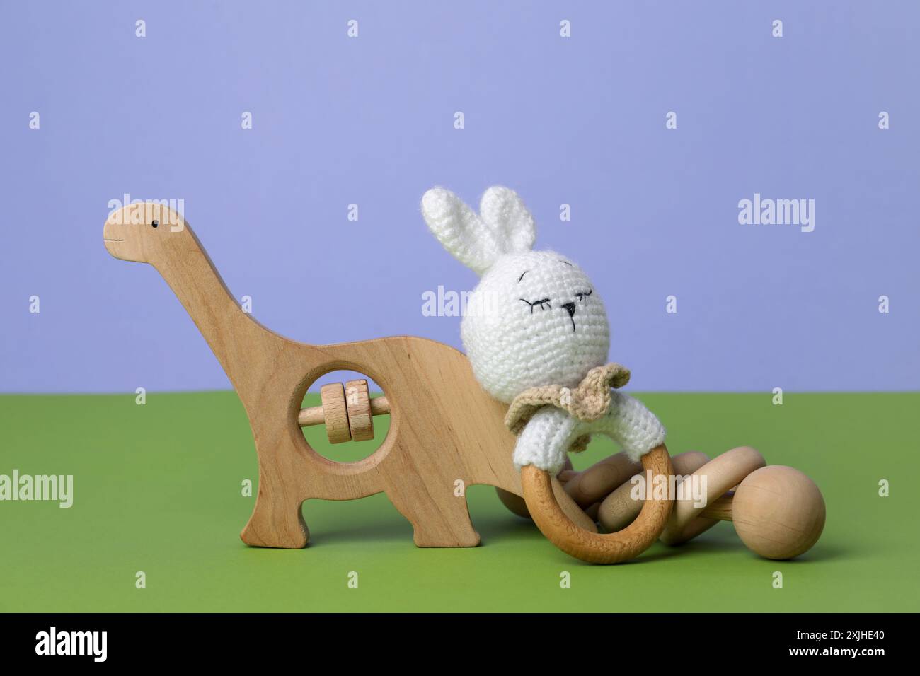 Different baby rattles on green table against blue background Stock ...