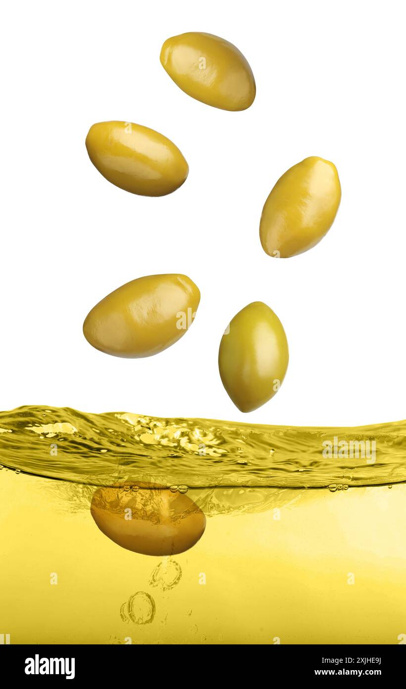 Green olives falling into cooking oil on white background Stock Photo ...