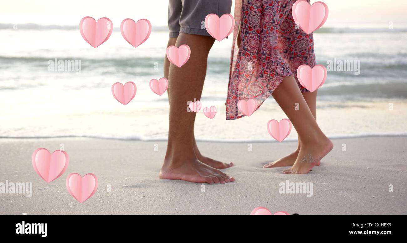 Image of hearts moving over legs of diverse couple in love on beach in ...