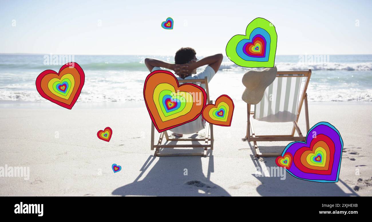 Image of hearts moving over diverse couple in love in deckchairs on ...