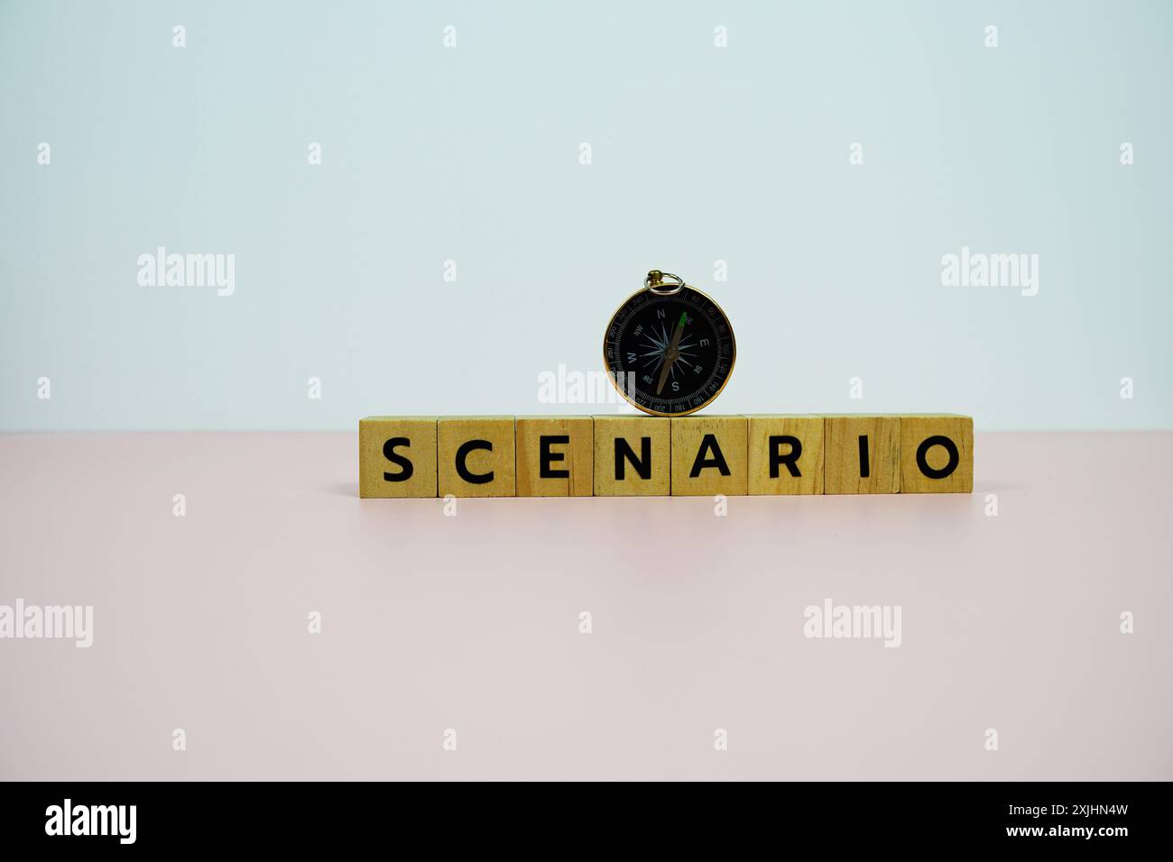 Compass with wooden blocks alphabet letters SCENARIO on pink background ...