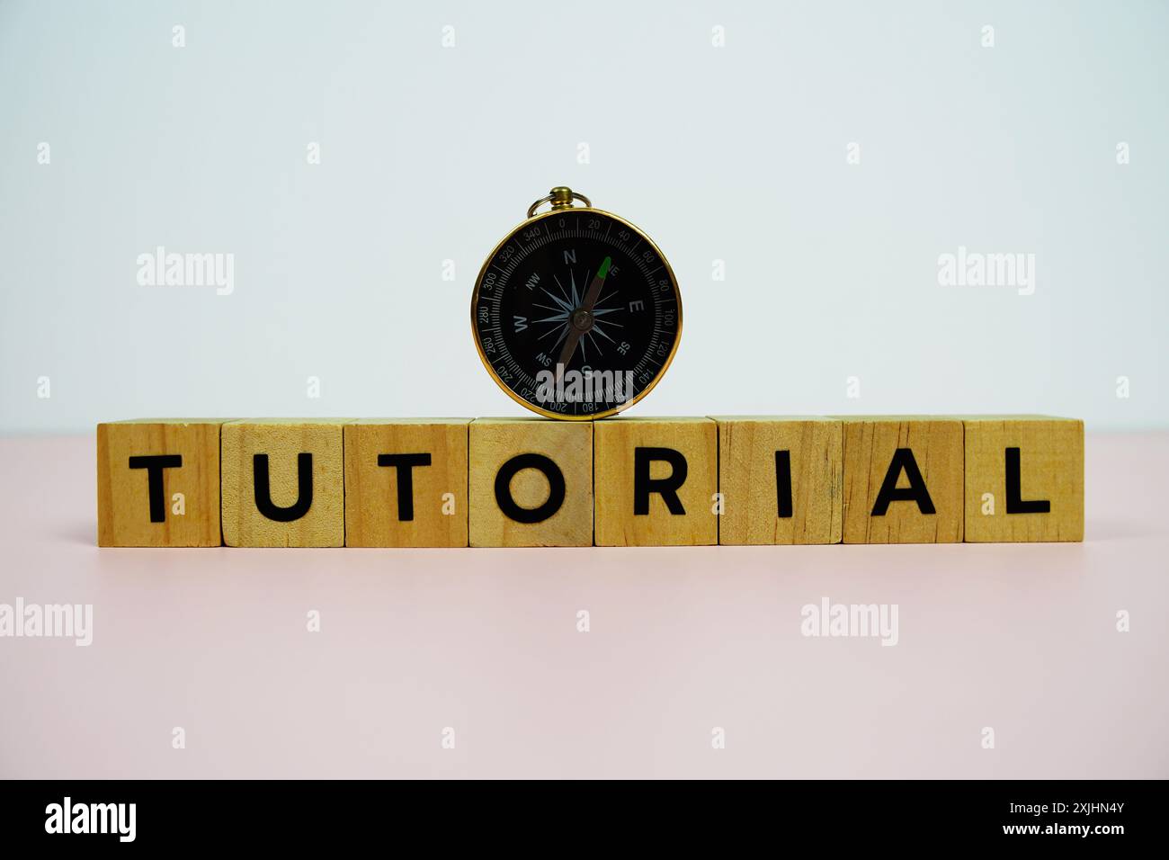 Compass with wooden blocks alphabet letters TUTORIAL on pink background ...